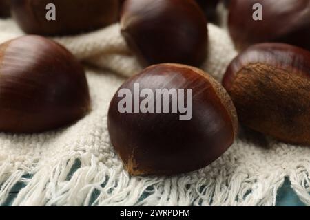 Roasted edible sweet chestnuts on grey textured table, closeup Stock ...