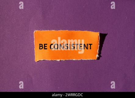 Be consistent words written on torn paper with purple background ...