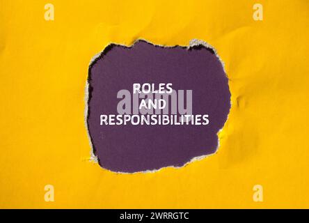 Roles and responsibilities words written on pink torn paper with yellow ...