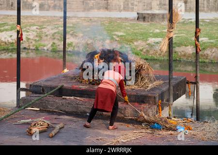 Staff employee of Pashupatinath Temple complex overseeing for funeral ...
