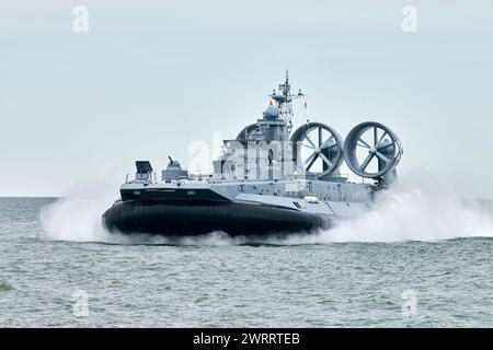 Hovercraft warship armed with armament sails into sea toward military ...