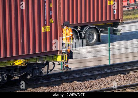 Shunter, railroad employee steers the freight train with containers ...