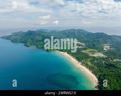White sandy beach with inshore waves. Blue sky and clouds. Carabao ...