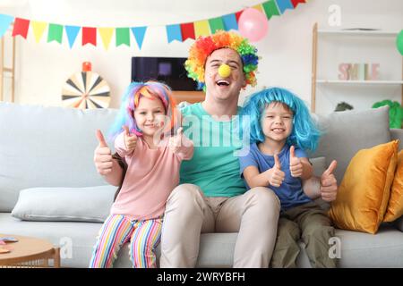 Father and his children with colorful wigs at home. April Fool's Day ...