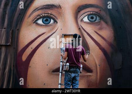 The street artist Jorit Agoch at work on a giant murales of Ilaria ...