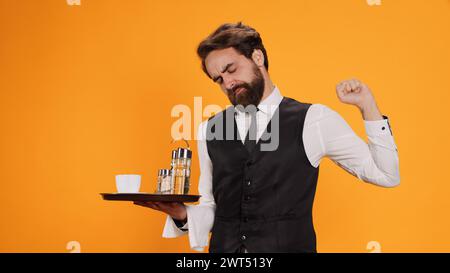 Overworked butler stretching in studio, feeling exhausted after long ...