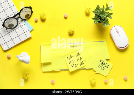 Computer keyboard taped with sticky notes on yellow background. April ...