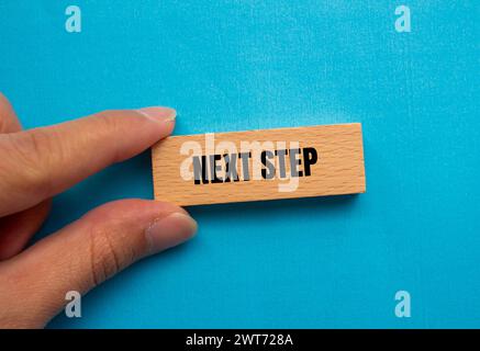 Next step words written on wooden blocks with blue background ...