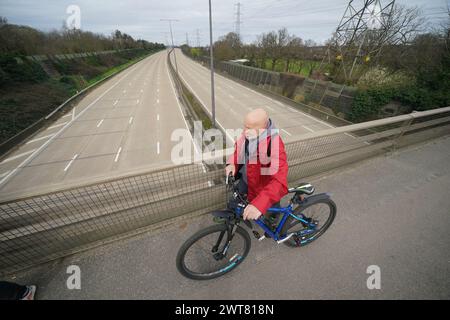 A man walks across the Parvis Road bridge in Byfleet, that crosses over ...