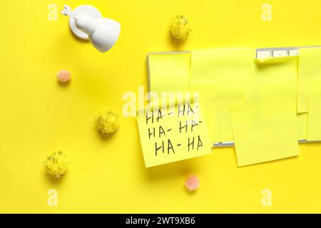 Computer keyboard taped with sticky notes on yellow background. April ...