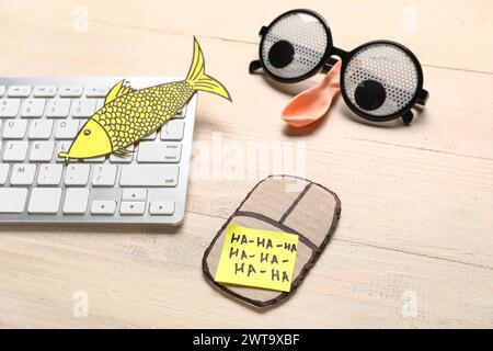 Funny glasses, computer keyboard and carton mouse on wooden background ...