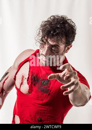 A man wearing a red T-shirt is shown from the back, holding his neck ...
