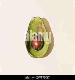 Emptied shell of an avocado and seed avocado with copy space on beige ...