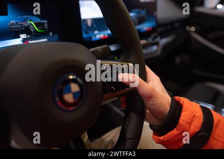 Interior, cockpit of BMW i5 eDrive40 car, digital panel, instruments on steering wheel, EV ...