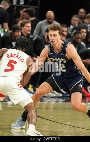 Toronto Raptors guard Immanuel Quickley, center, sits on the bench ...