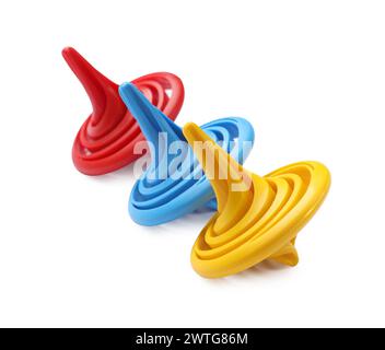 Three colorful spinning tops on white background Stock Photo - Alamy