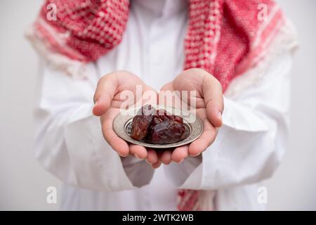 arabic man holding dates represents hospitality and generosity wearing ...