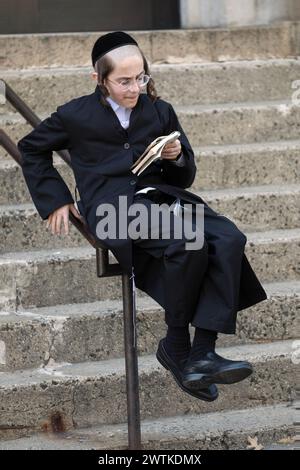 An Ultra-Orthodox Jewish yeshiva student walks past candles marking the ...