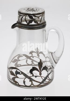 A decorative pitcher with a curved handle and a spout, featuring ...