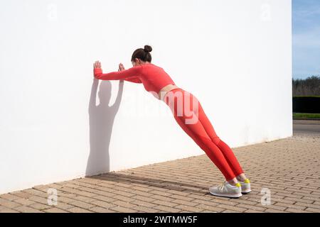Sporty woman doing push off exercises against a wall Stock Photo - Alamy