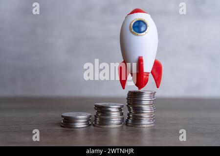 Closeup image of rocket spaceship and coins. Business startup, launch ...