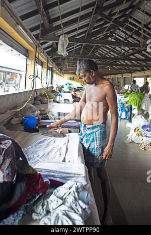 Indian man ironing laundry at Dhoby Khana laundry, Kochi, Kerala, India ...