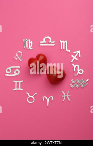 Zodiac signs and red hearts on pink background, flat lay Stock Photo ...