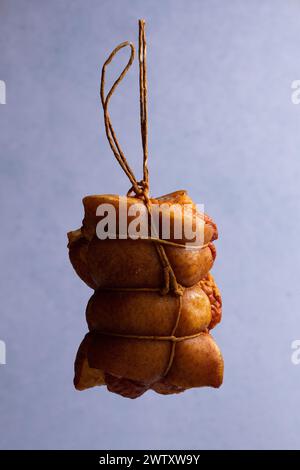 smoked spicy pork roll levitates on blue background Stock Photo - Alamy