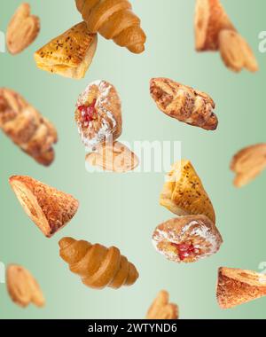 Different tasty puff pastries falling on green background Stock Photo ...