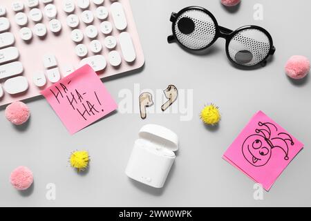 Carton earphones, sticky notes, computer keyboard and calendar on white ...