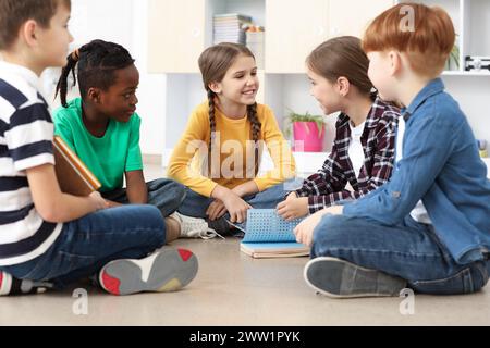 Cute children discussing in classroom at school Stock Photo - Alamy