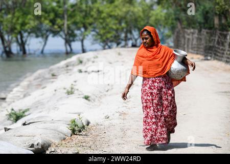 A woman is returning from collecting drinking water from a reverse ...