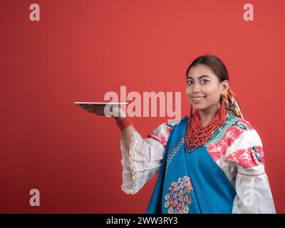 Hispanic girl of Kichwa origin with a red background and holding a ...