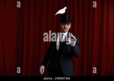 Magician performing a trick and a white dove flying from his hand ...