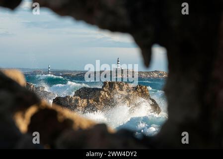 View through an arched rock of En Pou lighthouse at Des Porcs Island ...
