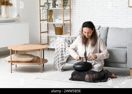 Beautiful mature woman with sticks playing glucophone and sitting on ...