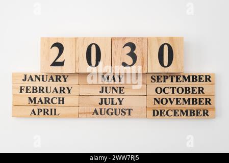 Wooden blocks and cubes with the year 2030 and the 12 months of the ...