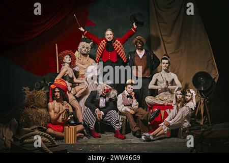 Diverse cast of vintage circus performers poses over dark retro circus ...
