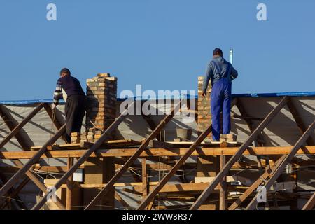Villagers working together to build a house rooftop Stock Photo - Alamy