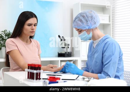 Laboratory testing. Doctor taking blood sample from patient at white ...