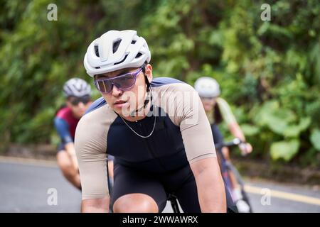 Asian male biker riding road bike, front view isolated on white ...