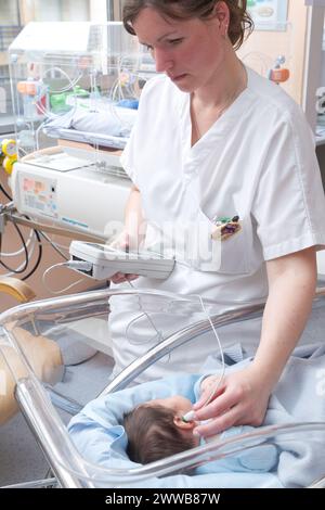 Hospital. Maternity. Hearing test - A childcare nurse performs a ...