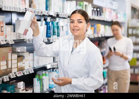 Female pharmacist puts goods on the shelves - healing cosmetics and ...
