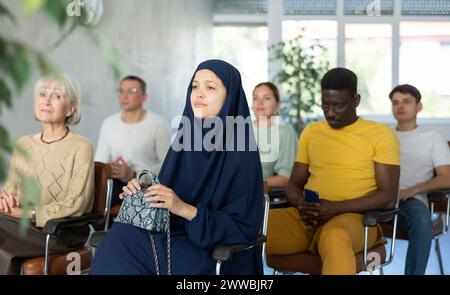 Positive multinational students listening to lecture in classroom Stock ...