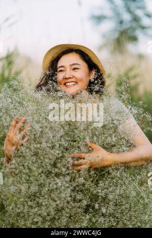Playful woman with bunch of gypsophila flowers in field Stock Photo - Alamy