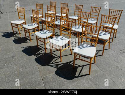Sunny seating. A parade of 15 chairs in the town square. Light and ...