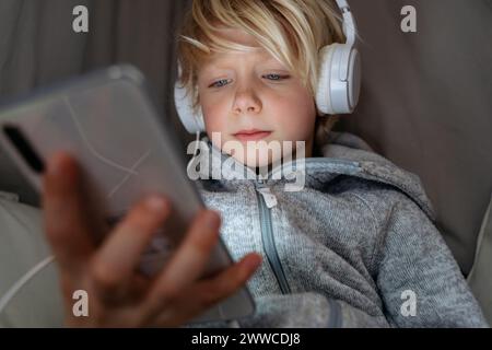 White headphones and part of smartphone on a black background ...
