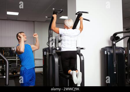Reabelitation after injury. An elderly woman plays sports in the gym ...