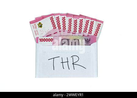 Indonesian rupiah currency. White envelope containing IDR 100,000 in ...
