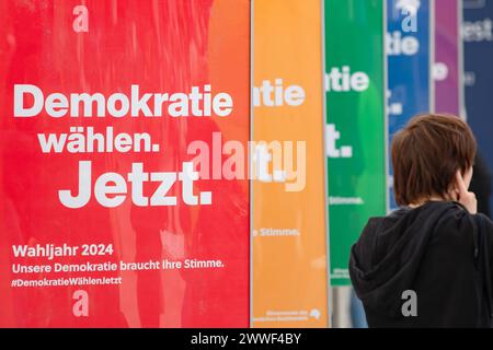 Besucher laufen vor Plakaten mit der Aufschrift Demokratie waehlen am ...